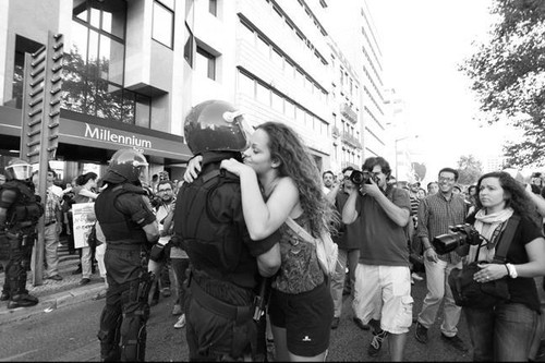 Portuguese protester hugging a police officer in front of the IMF ...